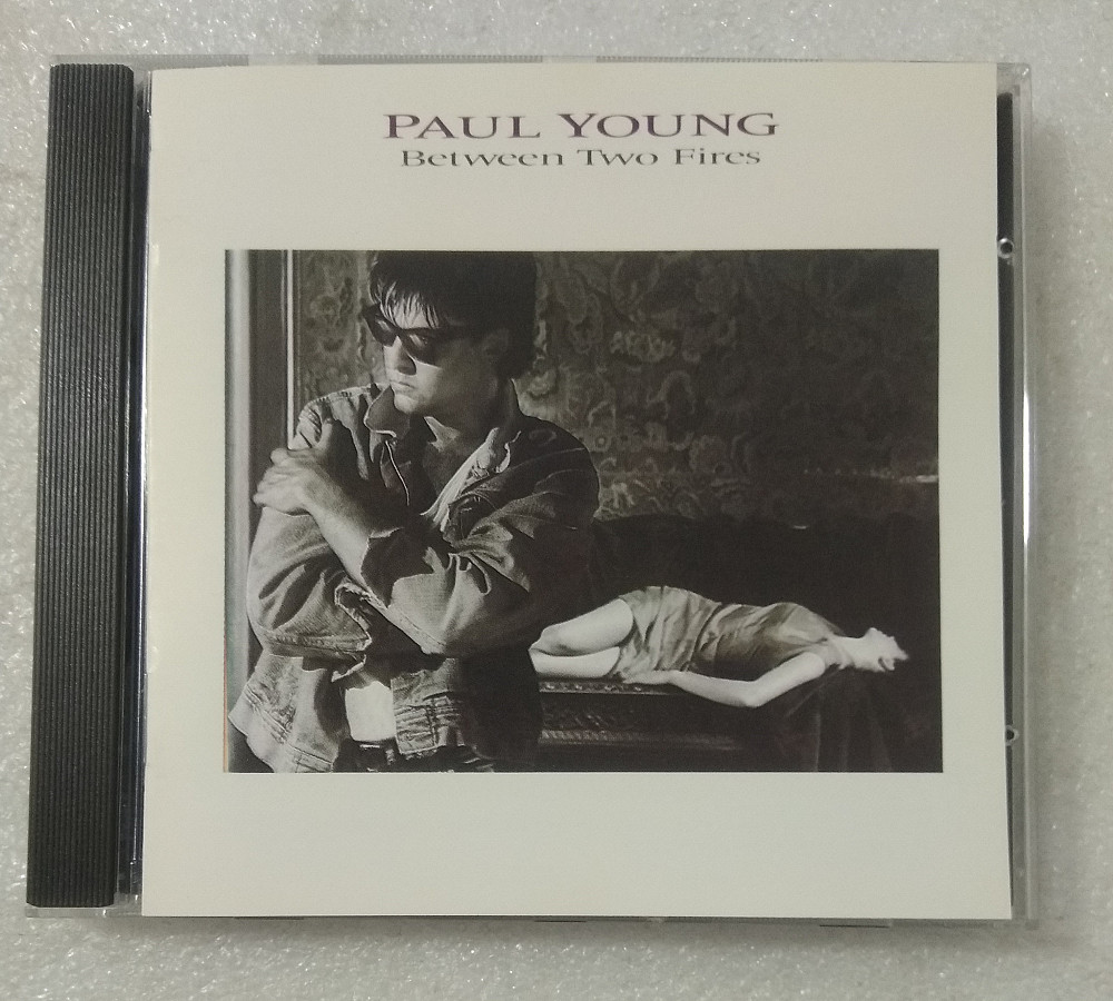 CD PAUL YOUNG 1986 Between Two Fires (Switzerland) | Vinyl.com.ua